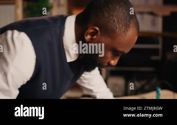 Young tailor marking fabric cloth to design fashion collection in ...