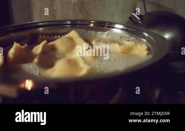 Close-up of cooking ravioli by placing them in a pan with boiling water ...
