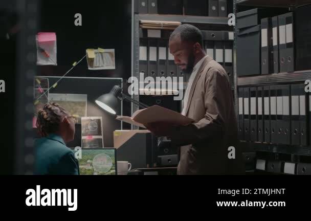 Partners checking evidence photos on detective map and searching ...