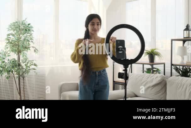 Indian vlogger creates content from home. In casual attire, she ...