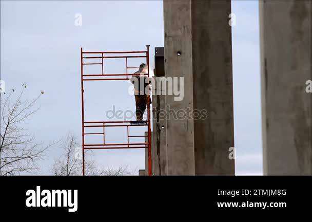 a welder working at height in the construction of large shopping ...