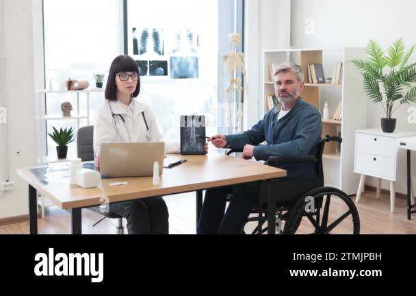 Full length portrait of female doctor and serious male patient with ...