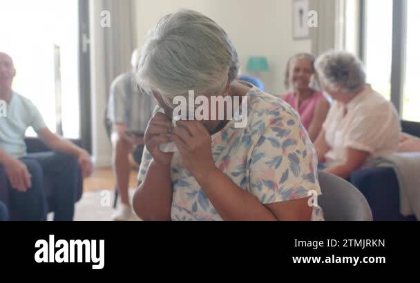 Distressed diverse seniors crying and talking in group therapy session ...