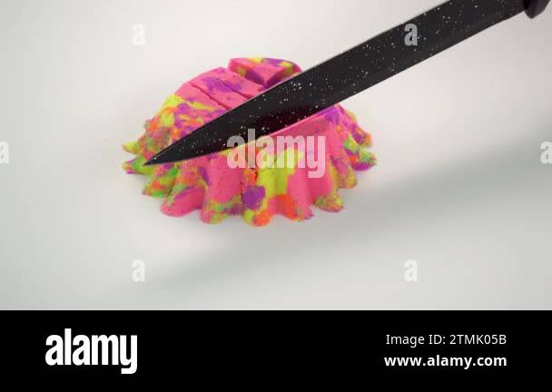 Kinetic sand cutting with a knife on a white background. ASMR sounds ...