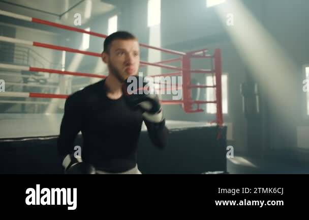 Young athletic boxer in boxing gloves exercises in gym doing shadow ...
