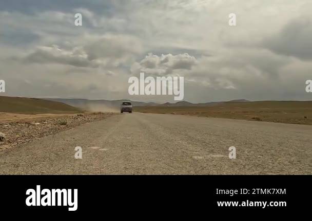A minivan drives along a deserted mountain road. Bottom view. An ...