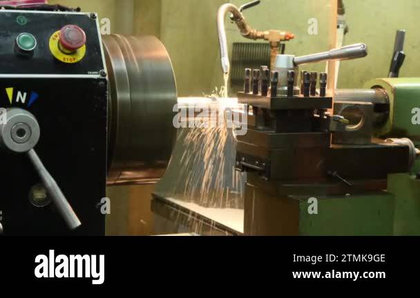 The lathe machine cutting the metal shaft parts with water base coolant method. The metalworking ...