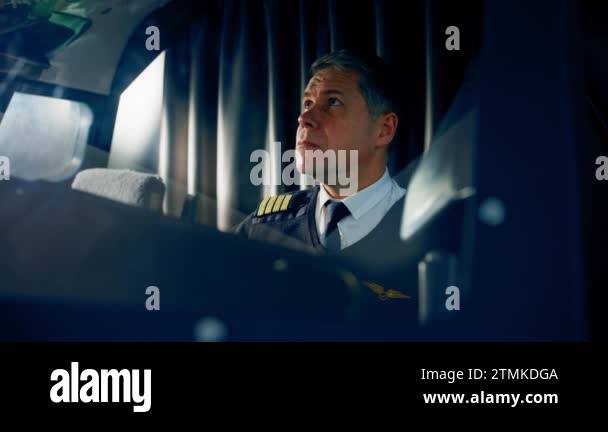 serious pilot of a modern passenger plane during flight in the cockpit ...