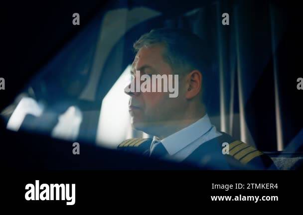 serious pilot of a modern passenger plane during flight in the cockpit ...