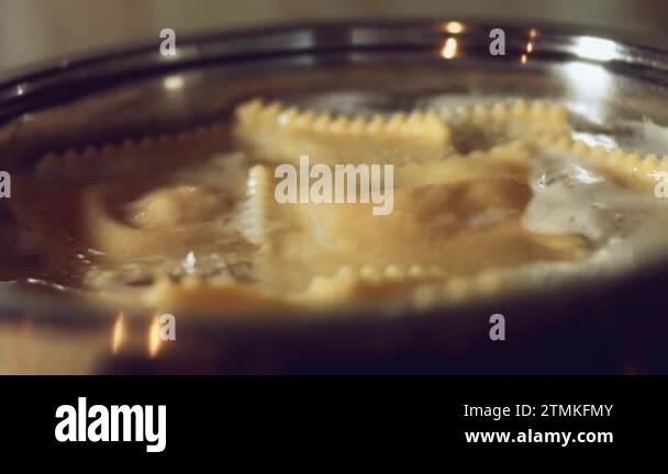 Close-up of cooking ravioli by placing them in a pan with boiling water ...
