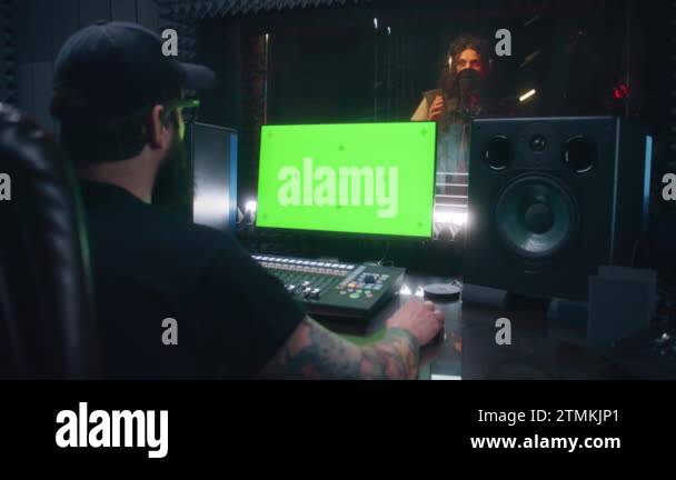 Male singer records song in soundproof room. Sound engineer uses ...