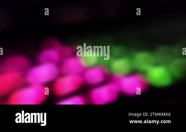 Overflow of multi-colored bokeh balls on a black screen. Blurred abstract background with ...