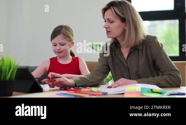 Mom or teacher teaches girl to draw using tablet. Teaching children to ...