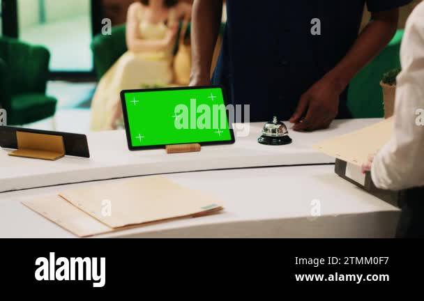 Guest asking about greenscreen info, pointing at tablet on reception ...
