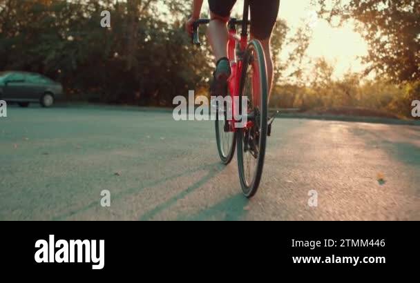 A man is riding a bike on road The camera is following him from behind ...