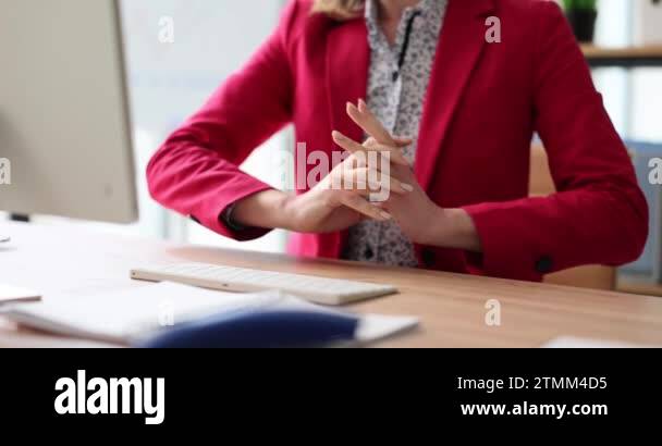 Woman employee in red jacket stretches arms interlocking fingers at ...
