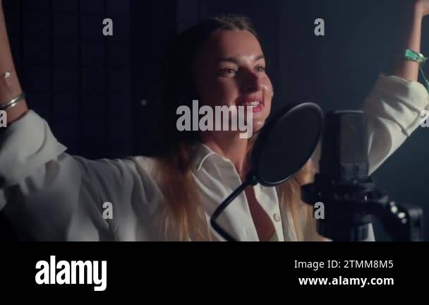 professional voice actress is dubbing and singing in isolation booth of ...