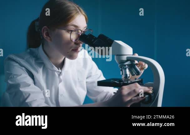 Scientist looking under microscope. Portrait of beautiful young ...