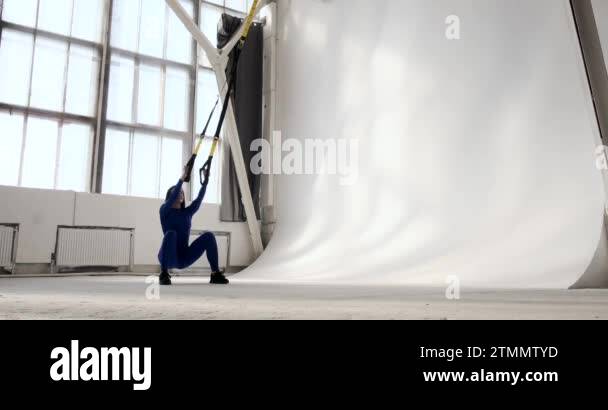 woman in a specialized sports outfit using resistance band loops to ...
