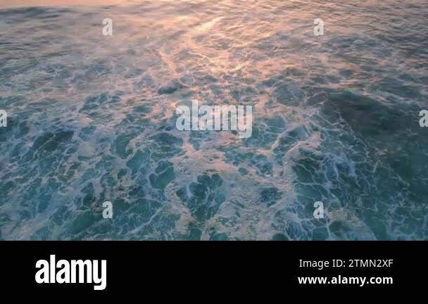 Stunning foamy sea water splashing on seashore stones super slow motion ...