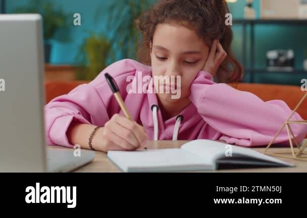 Bored tired preteen school girl using laptop for online lesson, doing ...