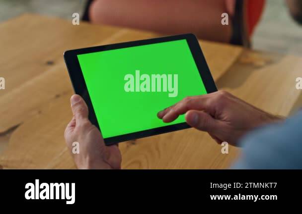 Man finger swiping greenscreen tablet at office. Close up anonymous ...