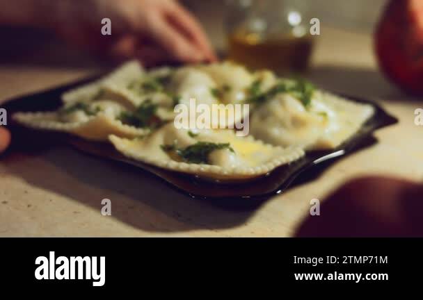 Close-up womans hand pouring melted butter with chopped parsley on hot ...