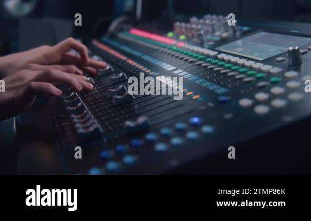 Musician uses mixing console, remote control for adjusting sound, audio mixer. Sound engineer ...