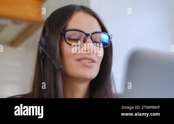 Portrait of a cheerful call center operator speaking with a client ...
