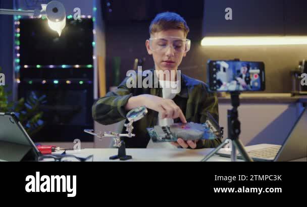 Teenage boy vlogger is recording video about computer motherboard ...