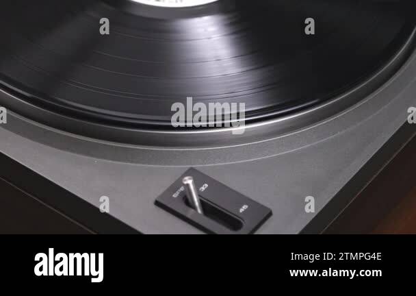 Black vinyl record spinning on the turntable with the speed selector ...