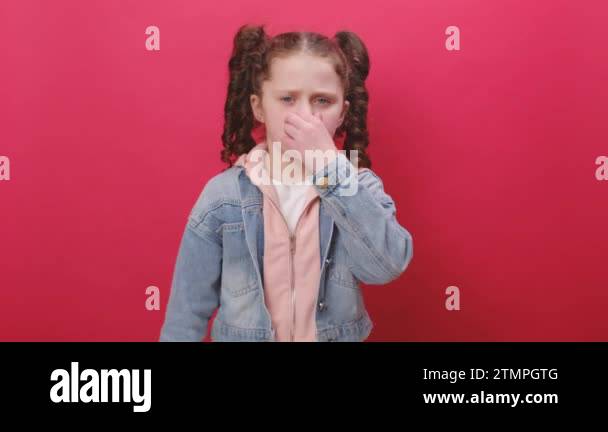 Portrait of preeten girl kid wearing denim jacket smelling something ...