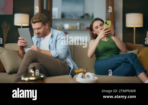 Love partners using gadgets at cozy house. Positive woman showing ...