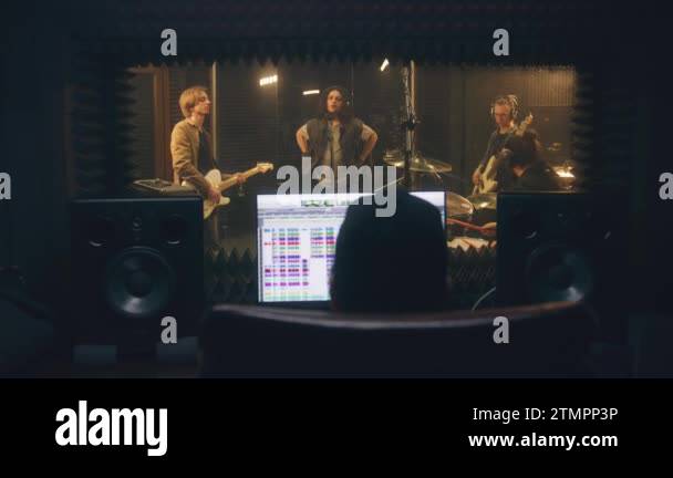 Musical band records song in music recording room. Audio engineer or ...