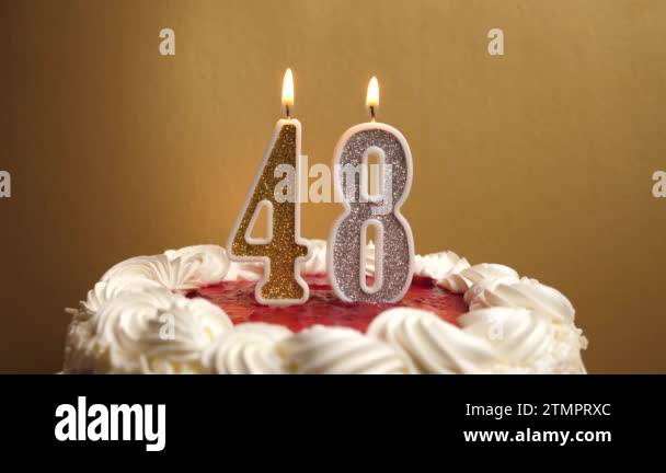 Blow out a candle in the form of the number 48, which is stuck into the ...