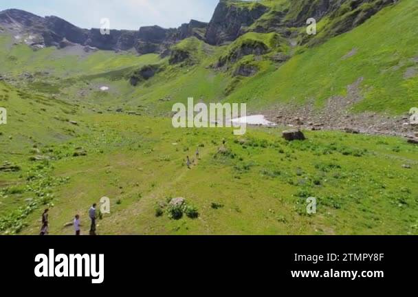 People walk by slope of mountain Stock Video Footage - Alamy