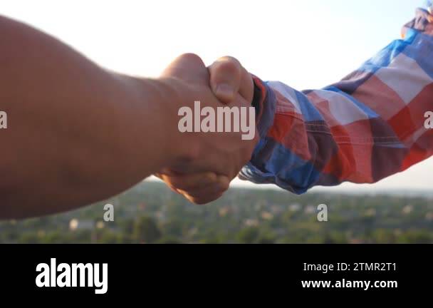 Friendly handshake of two unrecognizable men on cityscape background ...