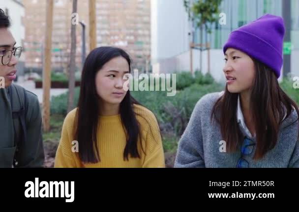 Young group of asian gen z student friends chatting together sitting at ...