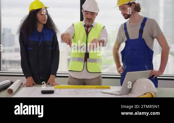 Professional construction engineers team using blueprint of project plan brainstorming and ...