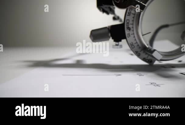 Optometric glasses for measuring visual acuity lie on paper Snellen ...