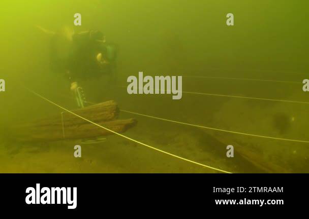 Underwater archaeological exploration: A scientist diver with a metal ...