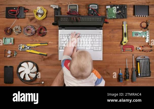 Kid sitting with his father for the workplace computer repair and press ...