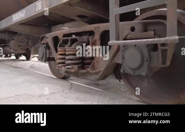 Closeup view of axle and wheels at lower end of railway wagon passing ...