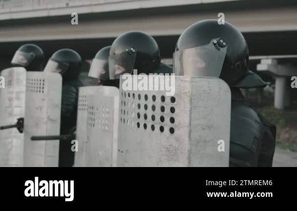 Armored Police Force Riot policeman with shield and baton suppressing ...