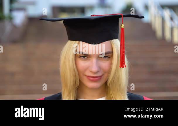 Attractive student girl with cap on head and wearing in black mantle ...