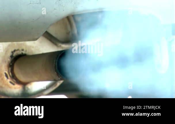 close up automobile car pipe exhaust smoke fumes toxic gas emission ...