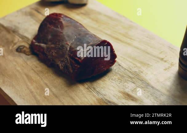 Chef cleans raw meat and cuts off connective tissue and surface ...