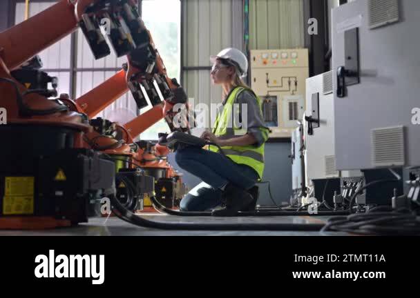 Maintenance engineer worker working with robotic machine automation at factory, Female ...