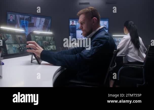 Male security officer touches tablet and controls CCTV cameras with AI ...