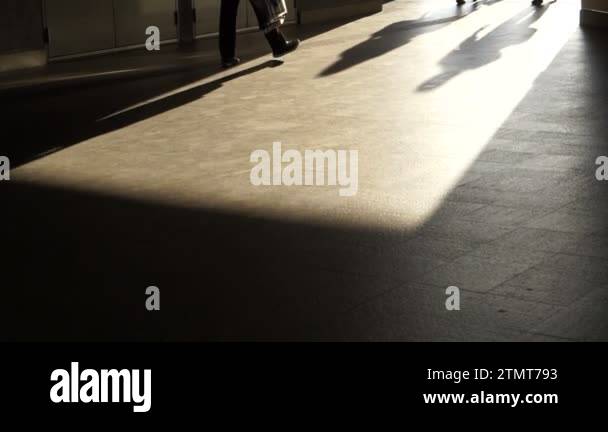 City people walking to commute in morning sunlight casting shadow on ...